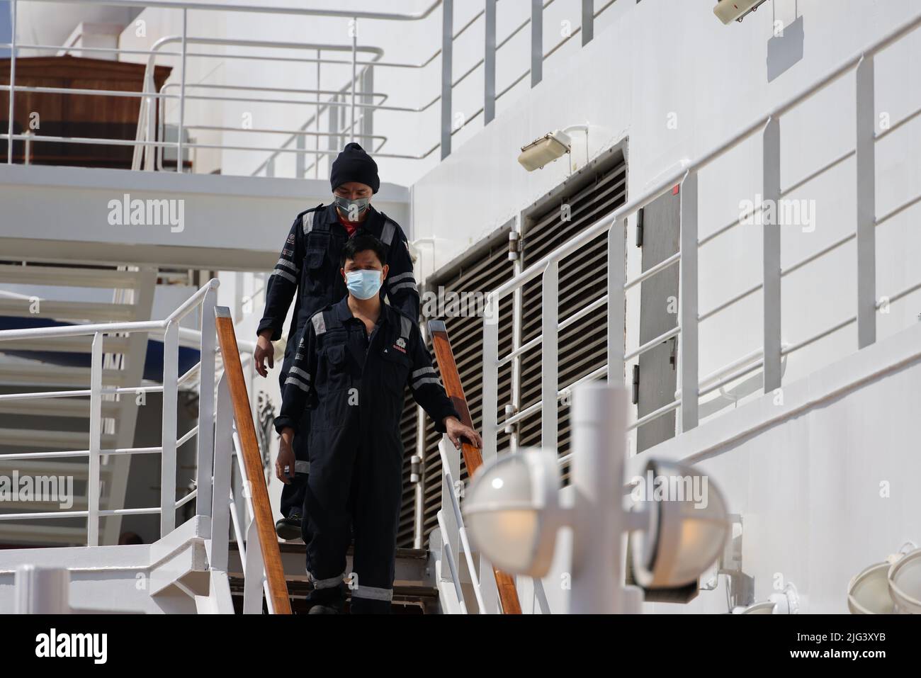 Masked maintenance cruise ship workers on their way to work Stock Photo ...
