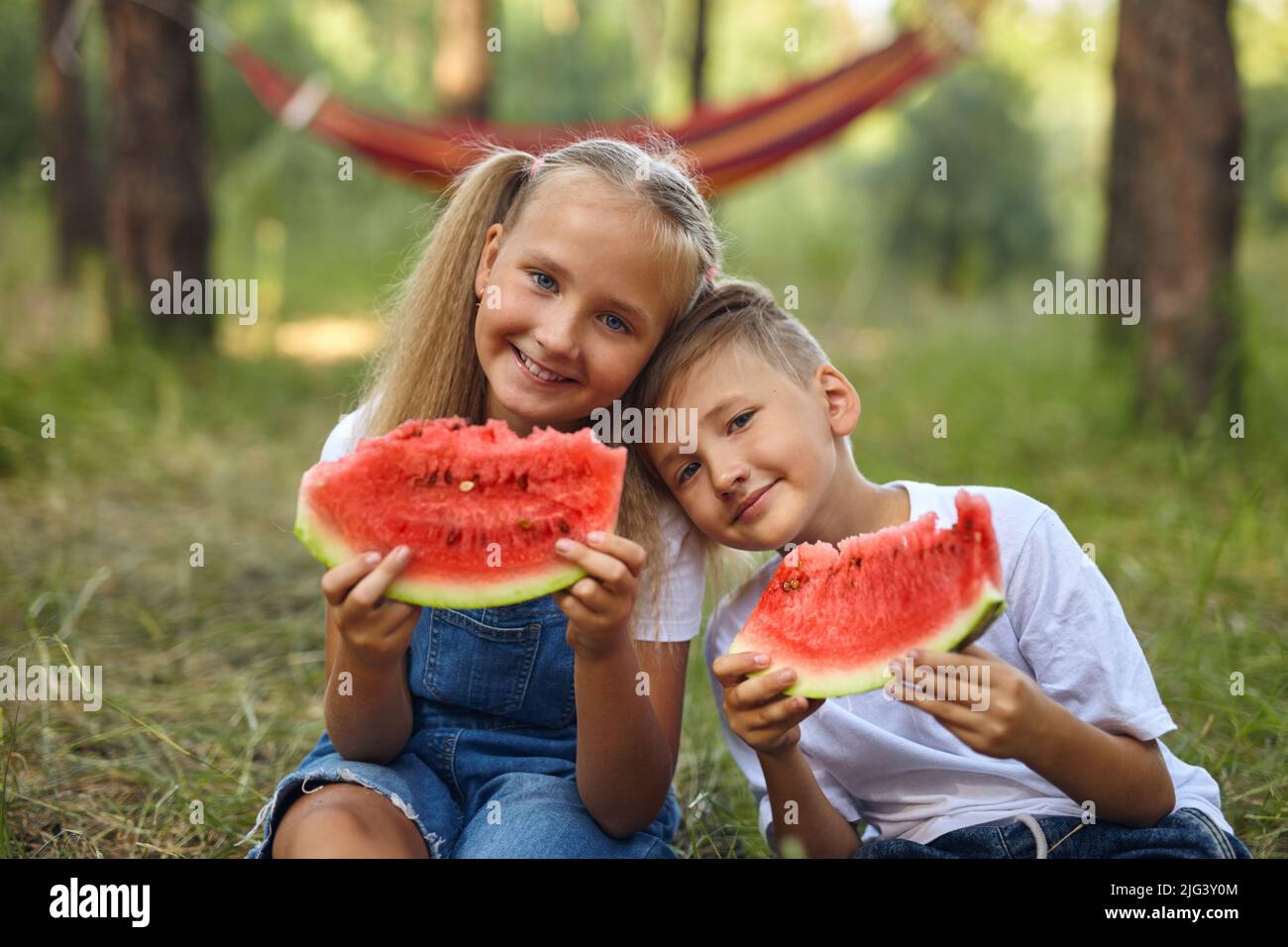 Cute kids eating watermelon in the garden Stock Photo - Alamy