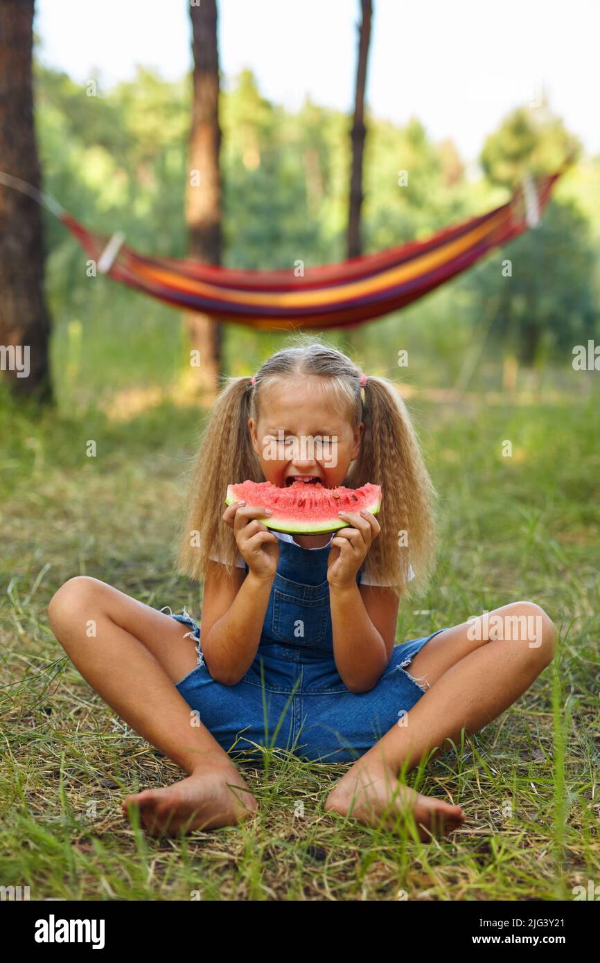 Kid girl eating watermelon in the garden Stock Photo - Alamy