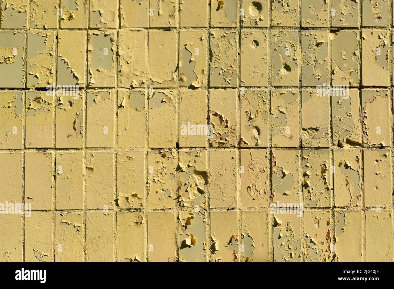 Texture of old tile wall. Yellow paint crumbled. Paint on top of tiles ...