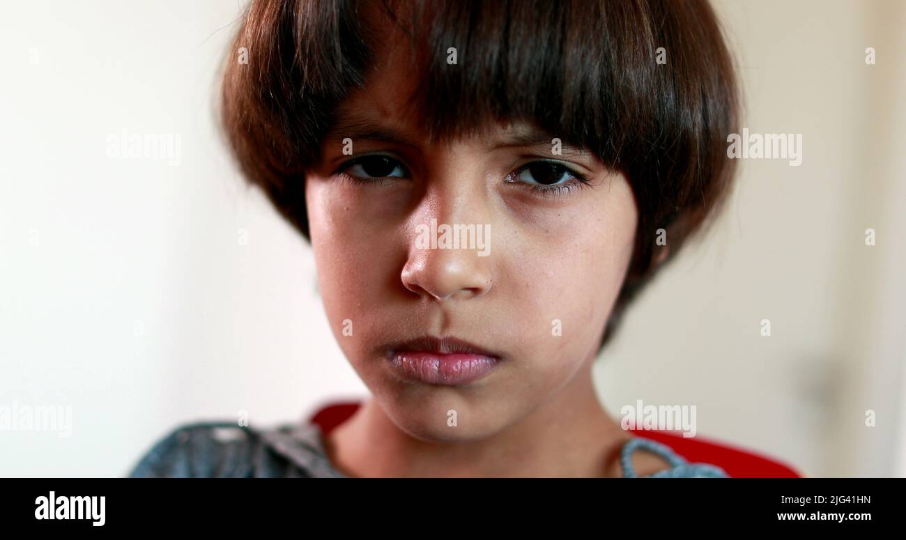 Upset mixed race young boy looking at camera portrait. Ethnically ...