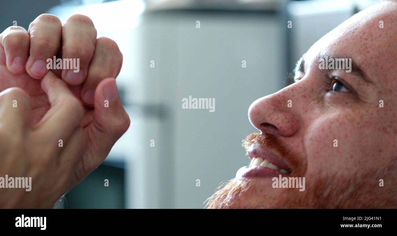 Victorious man celebrating with fist in air looking up to sky with hope ...