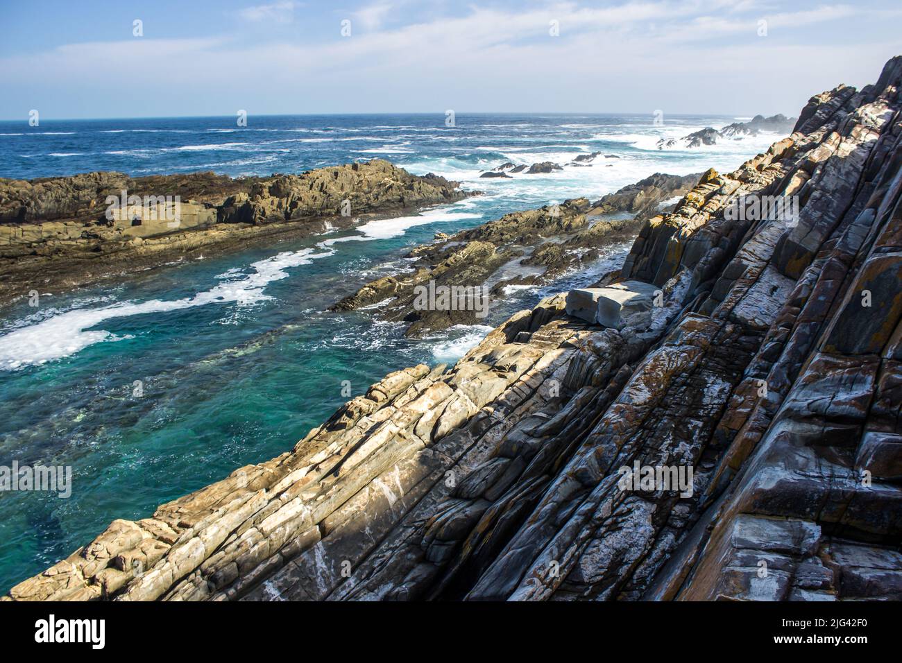 Where Turquoise water meets the rocky Coast. Looking along the tilted ...