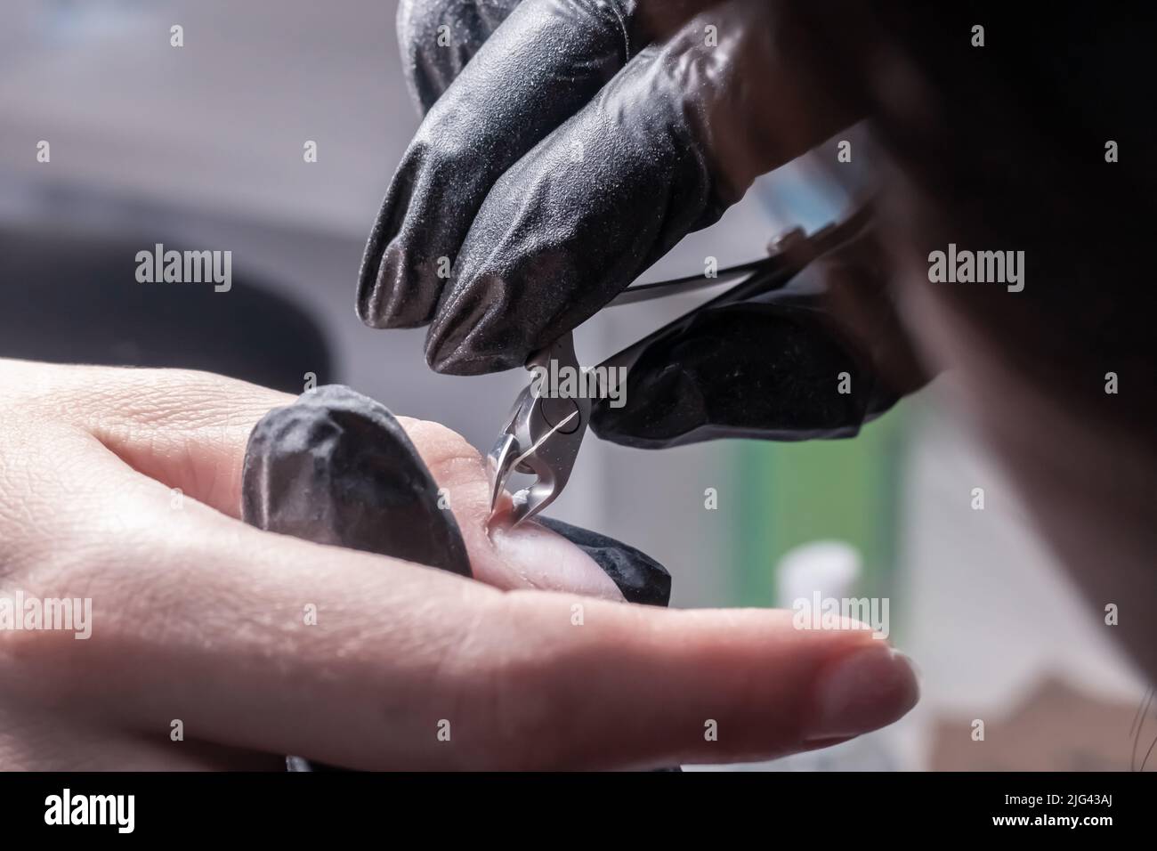The process of manicure in a beauty salon close-up. Cuticle removal ...