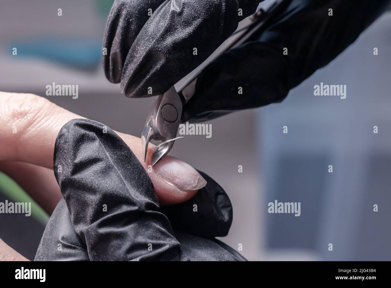 The process of manicure in a beauty salon close-up. Cuticle removal ...