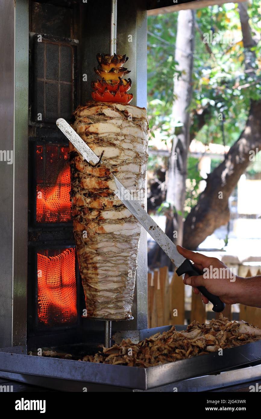 A chicken shawarma skewer roasting on a rotating pole Stock Photo - Alamy