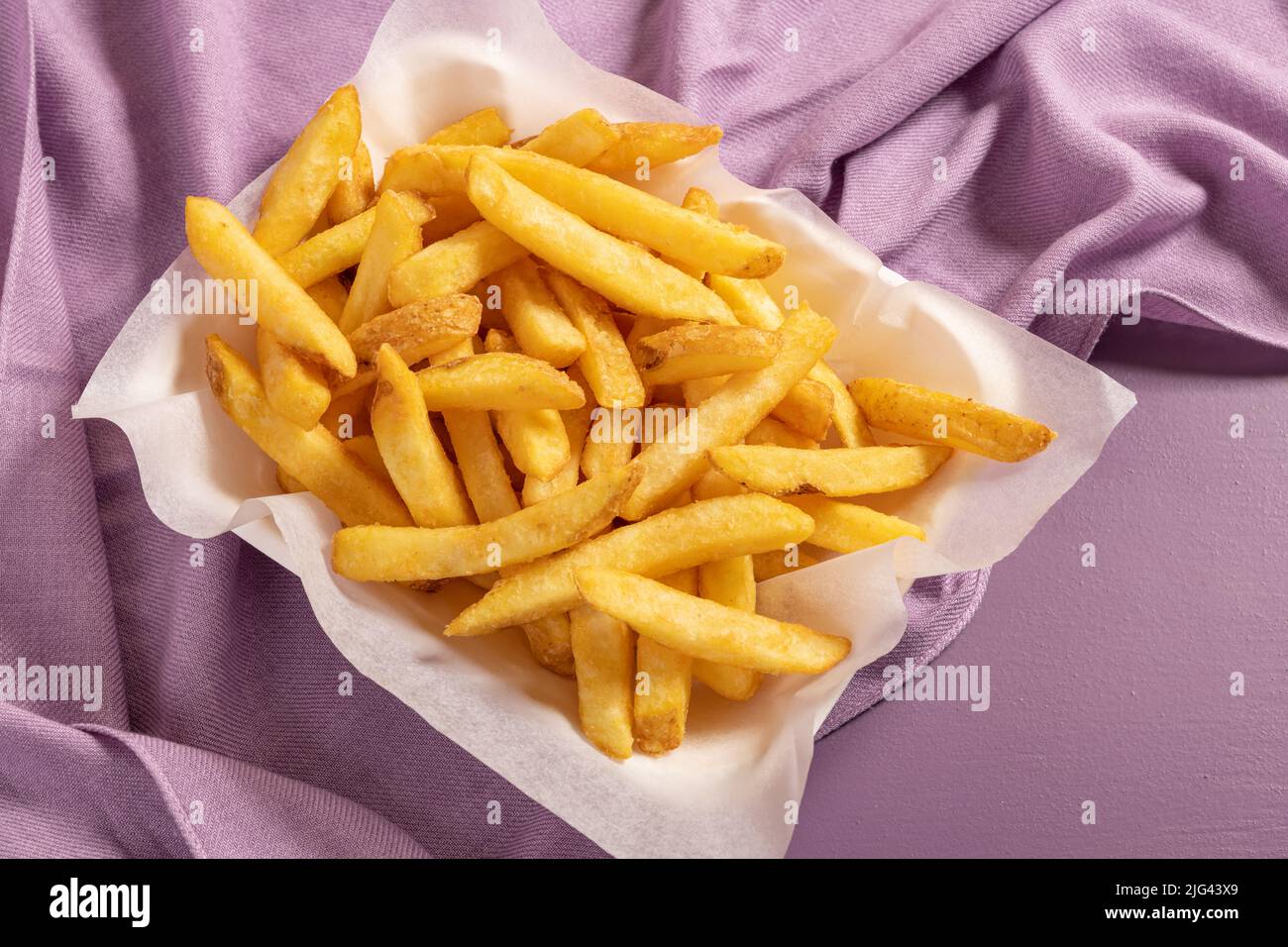 Fries portion on soft purple background Stock Photo - Alamy