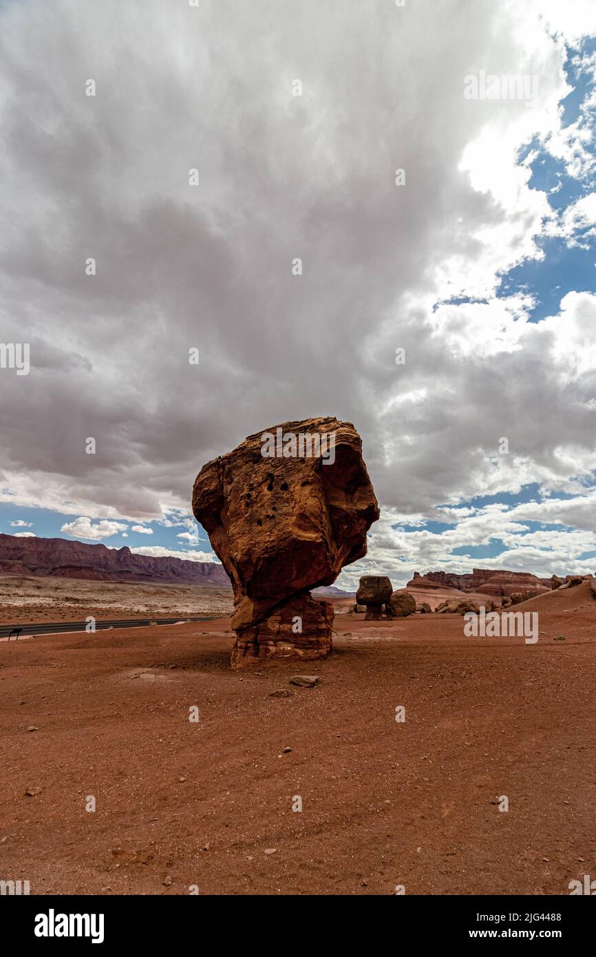Super sized boulder stands under the cloudy sky, Vermillion cliff range ...