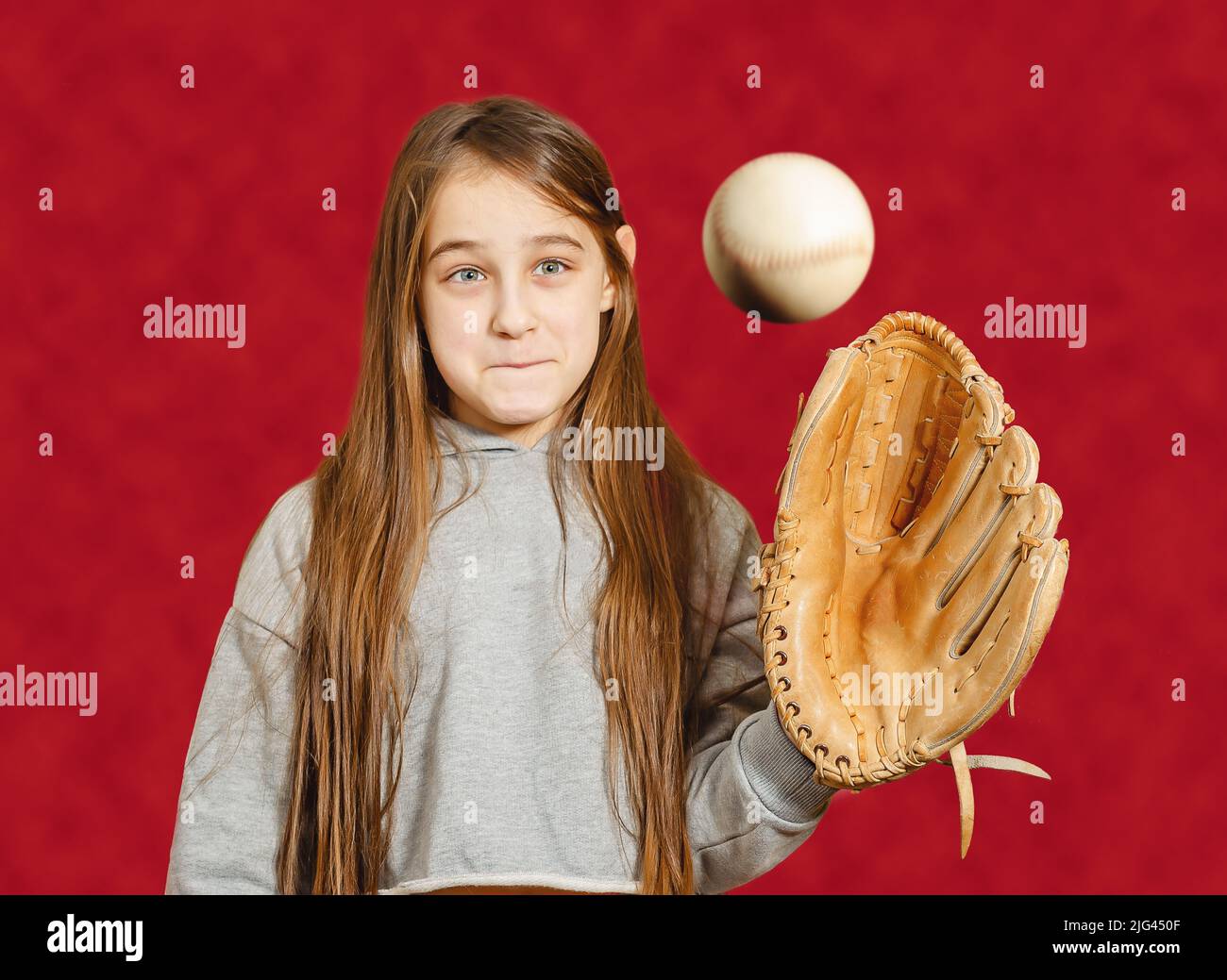 Child with baseball glove and ball. Girl with long hair catches ball ...