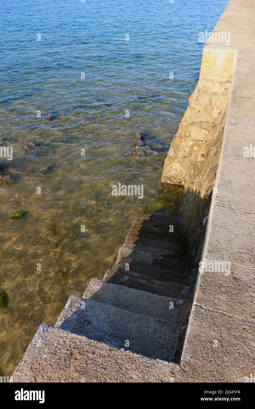 Concrete steps leading down to the sea from a jetty Stock Photo - Alamy