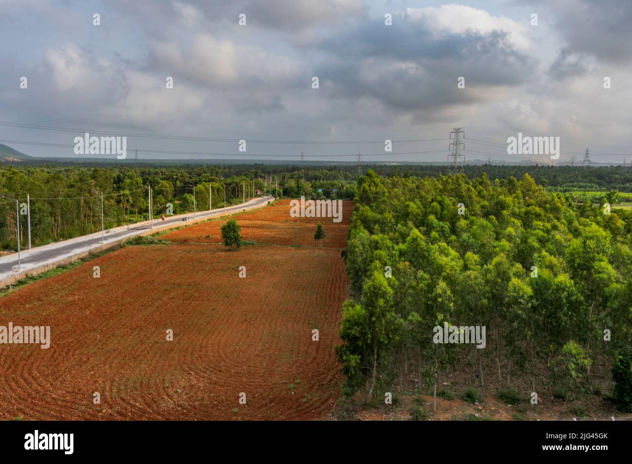 Road side red soil farm ready for paddy seeding by a tractor in a ...