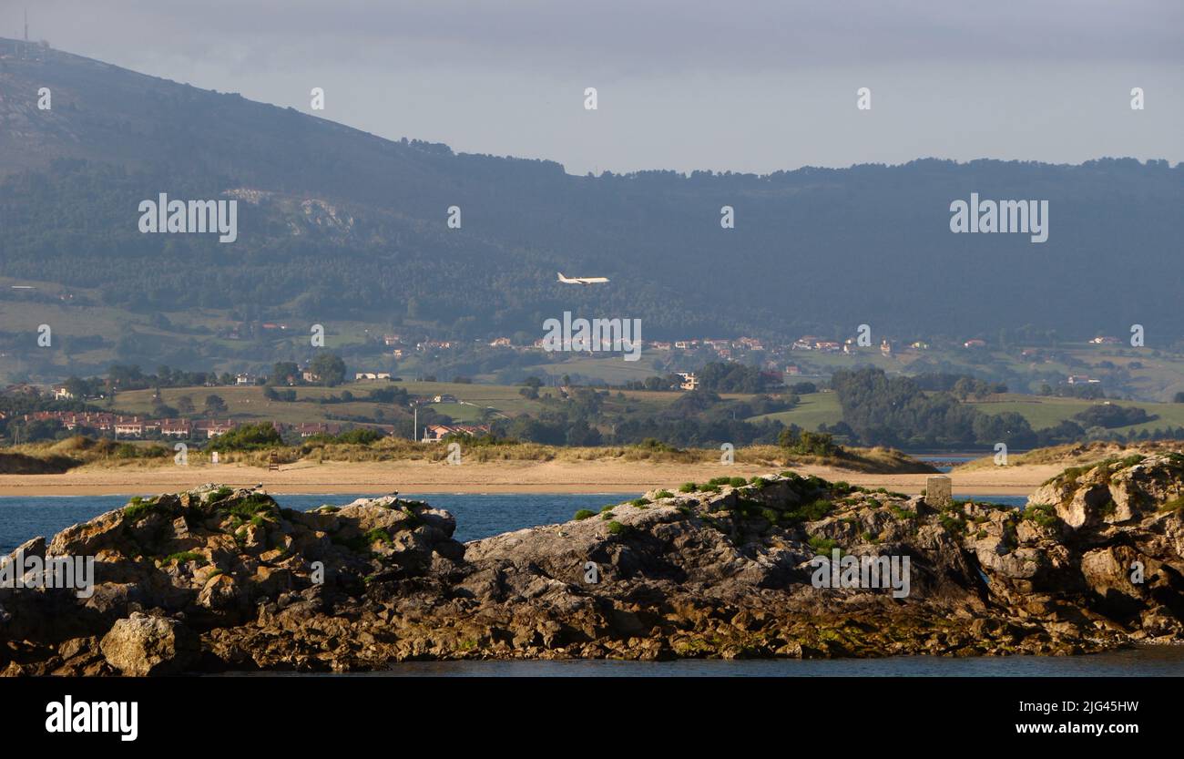 A passenger jet landing at Santander airport seen from across the bay ...