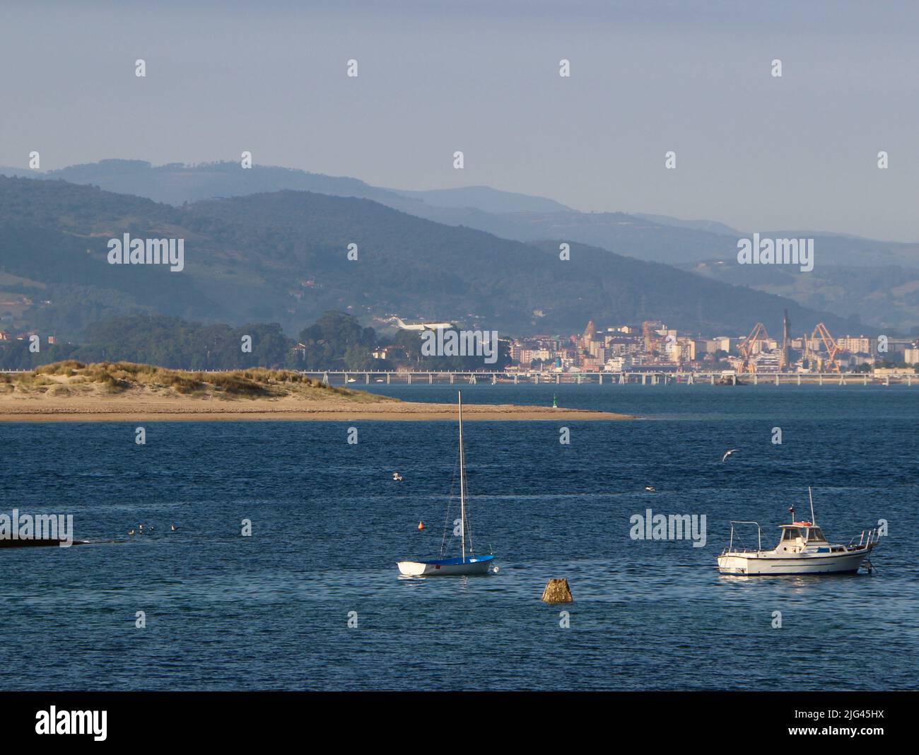 A passenger jet landing at Santander airport seen from across the bay ...