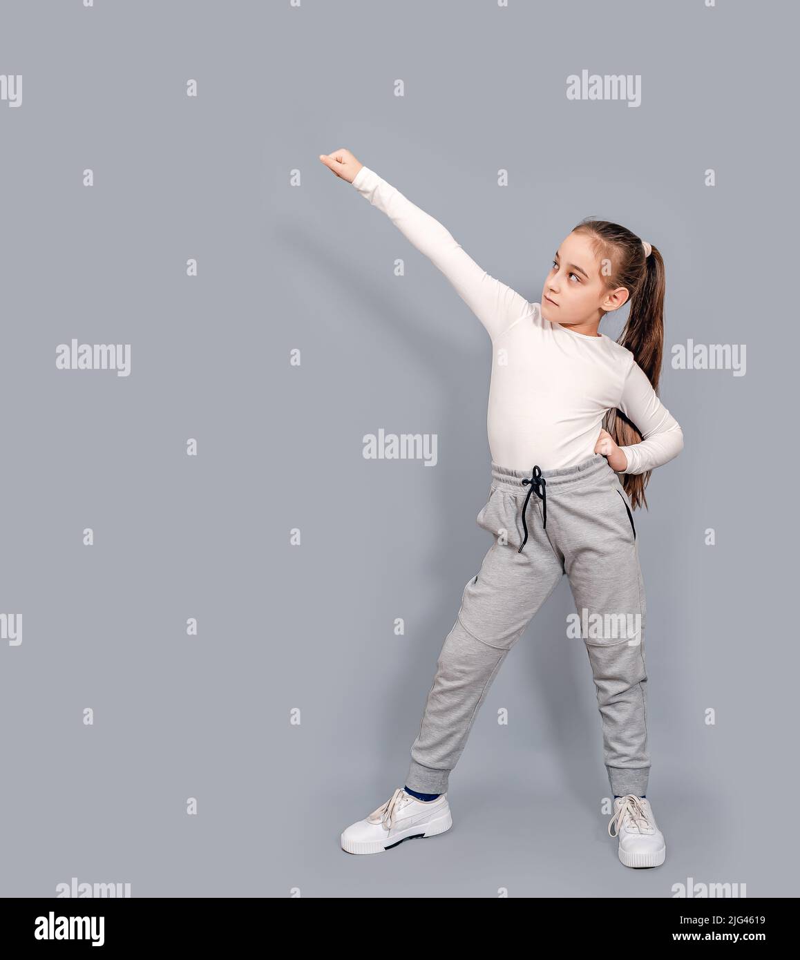 Determined, cool little girl raised her hands. Little girl shows ...