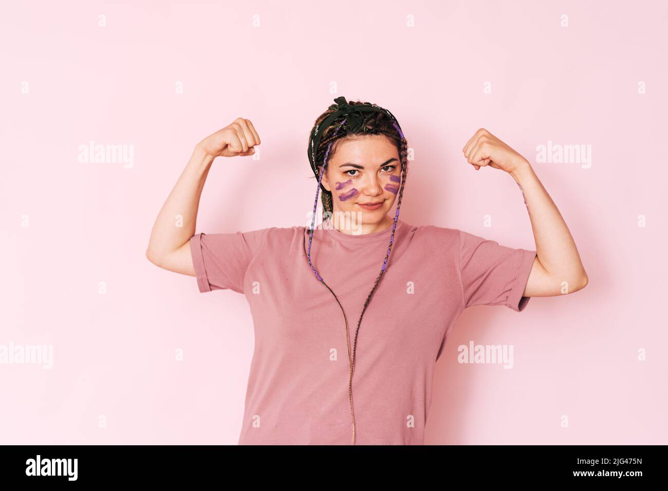 Girl with purple paint on her face shows strength Stock Photo - Alamy