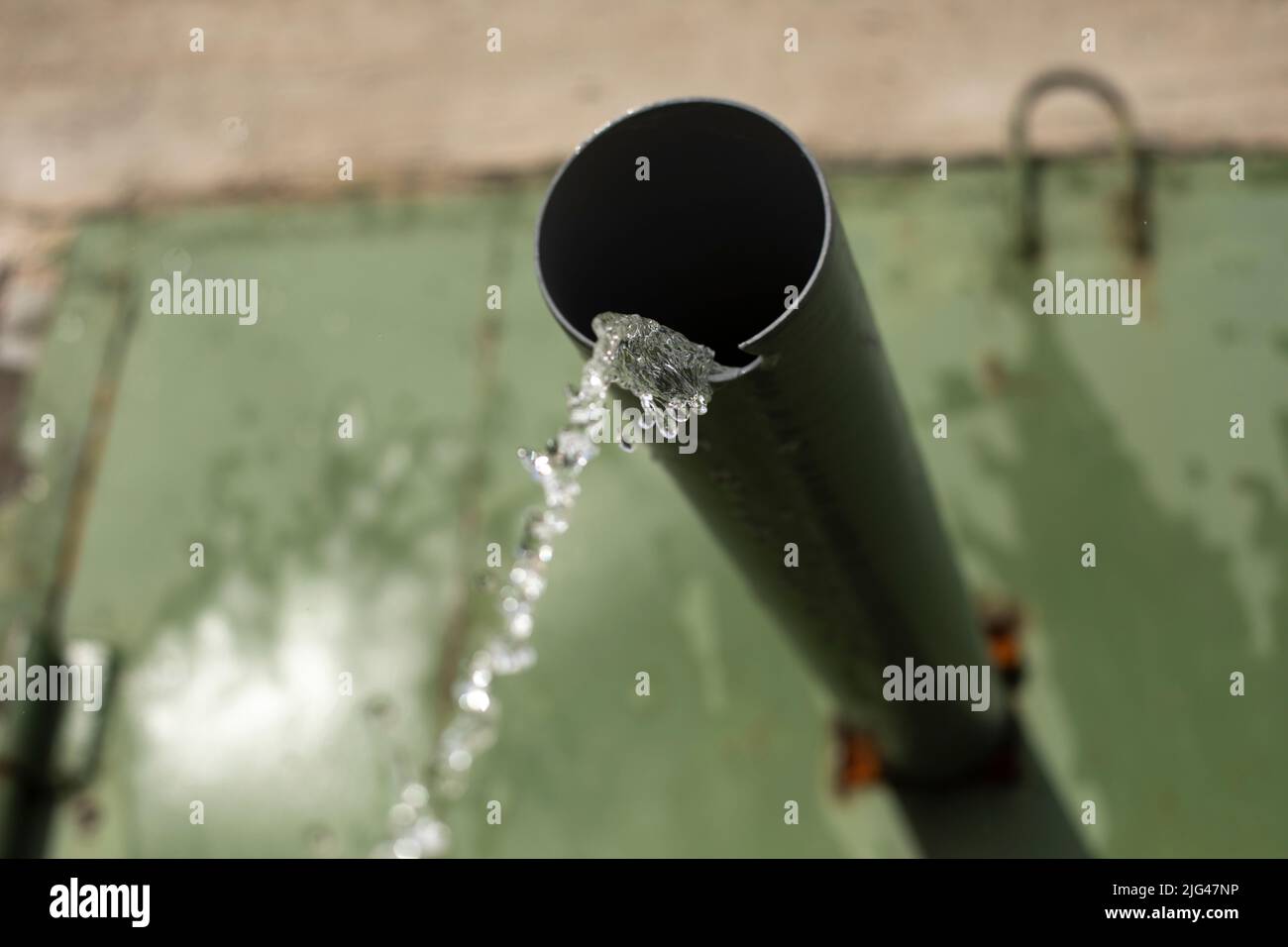 Water pours out of pipe. Details of building Stock Photo - Alamy
