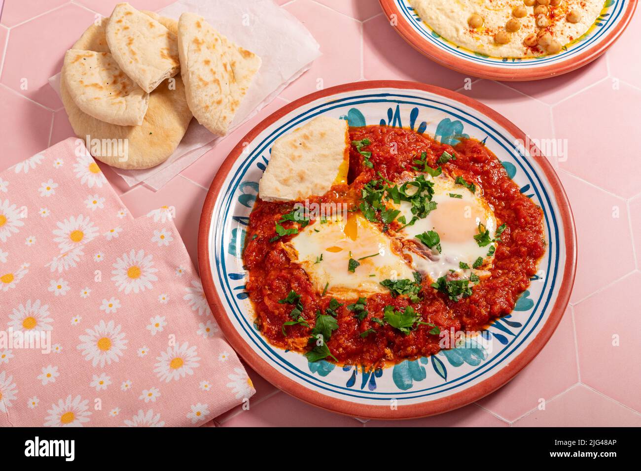 Homemade shakshuka hot breakfast topped with fresh herb leaves and ...