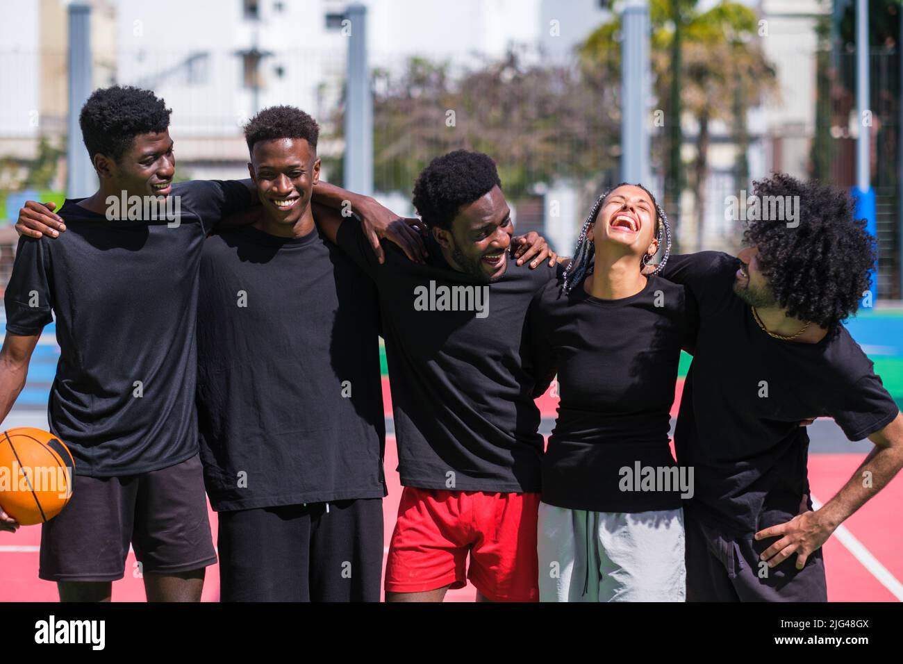 Group of young people having fun together after playing basketball ...