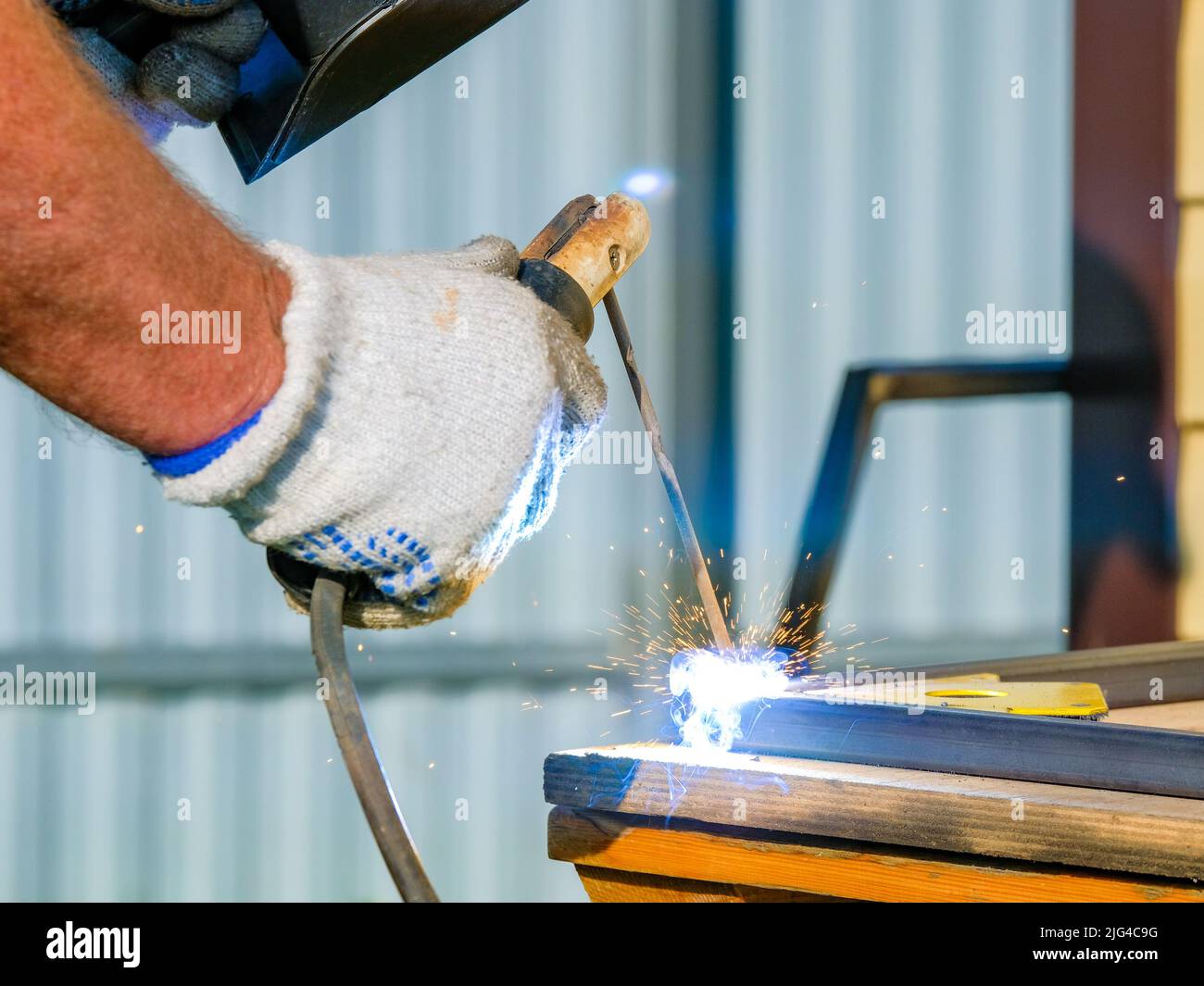 Selective focus of the electrode in the hand of a welder cutting metal ...