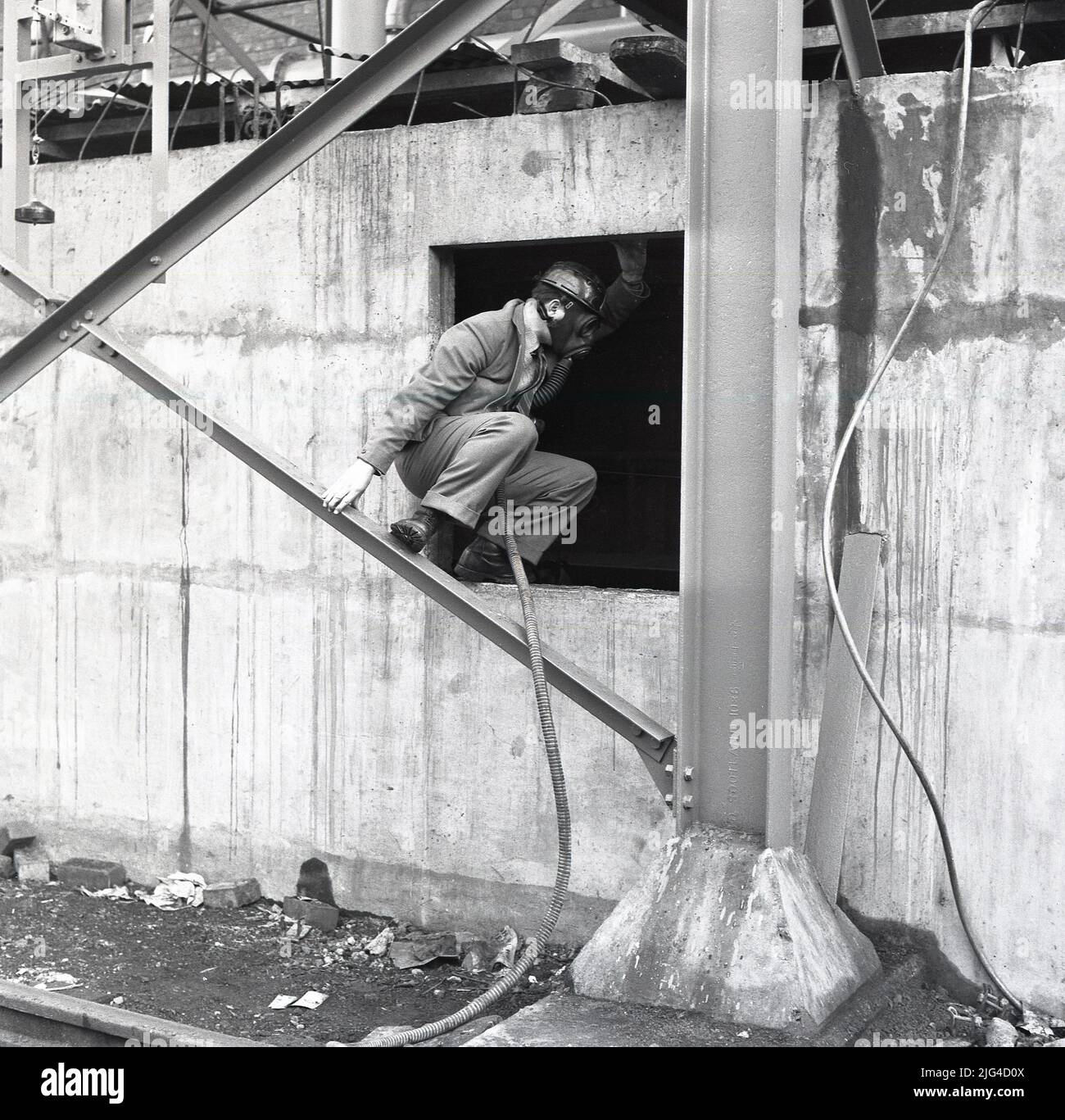 1950s, historical, a male employee with breathing apparatus on his face ...