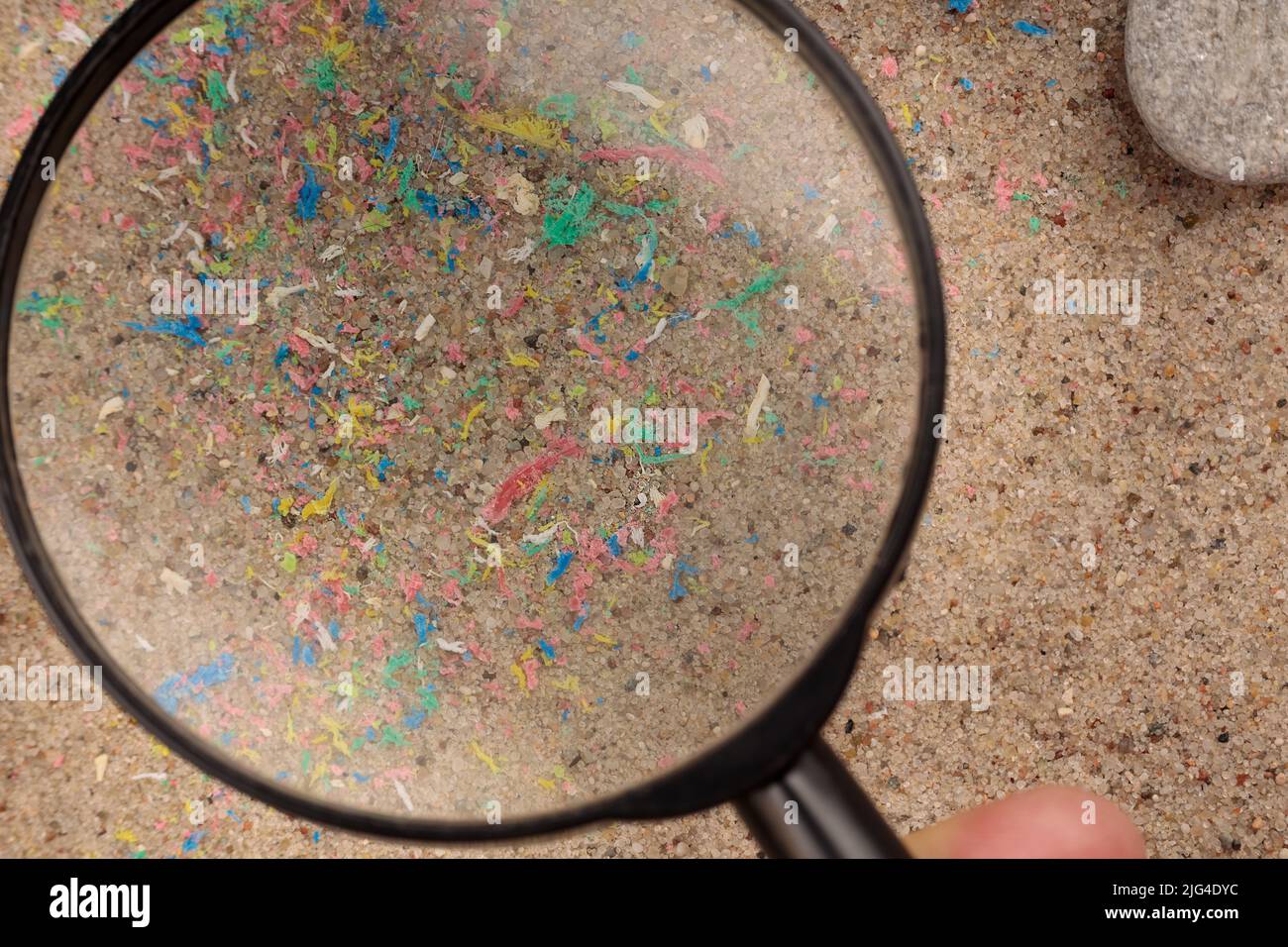 Micro plastic on sand under magnification, under a magnifying glass ...