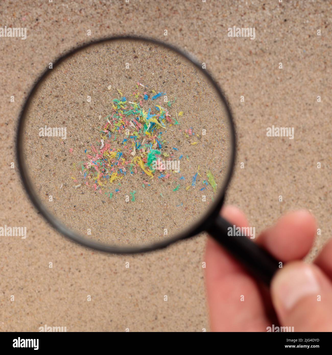 Micro plastic on sand under magnification, under a magnifying glass ...