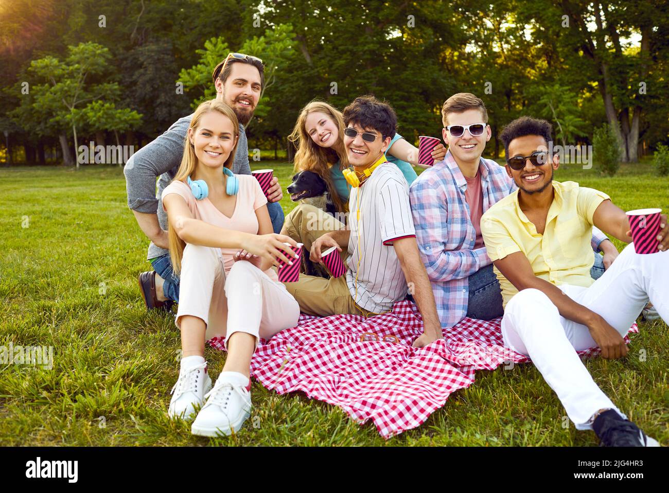 Portrait of group of happy friends relaxing together on small impromptu ...