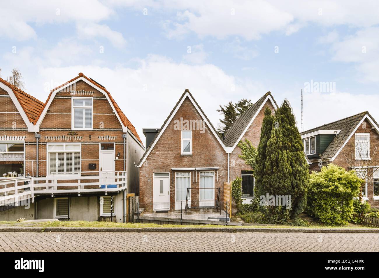The front view of a brick building with signs, pavement and wooden ...