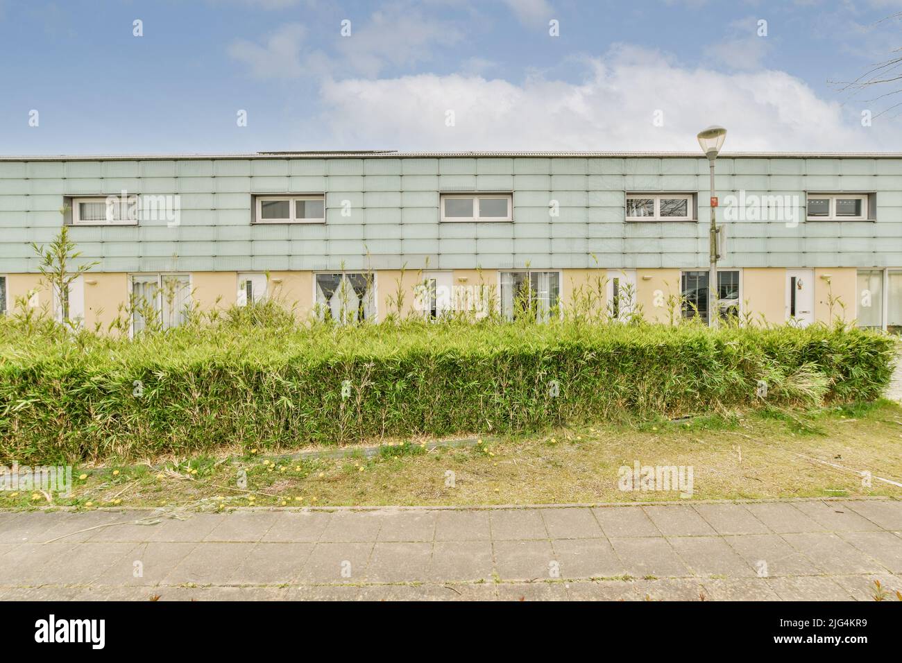 The front view of a brick building with signs, pavement and wooden ...
