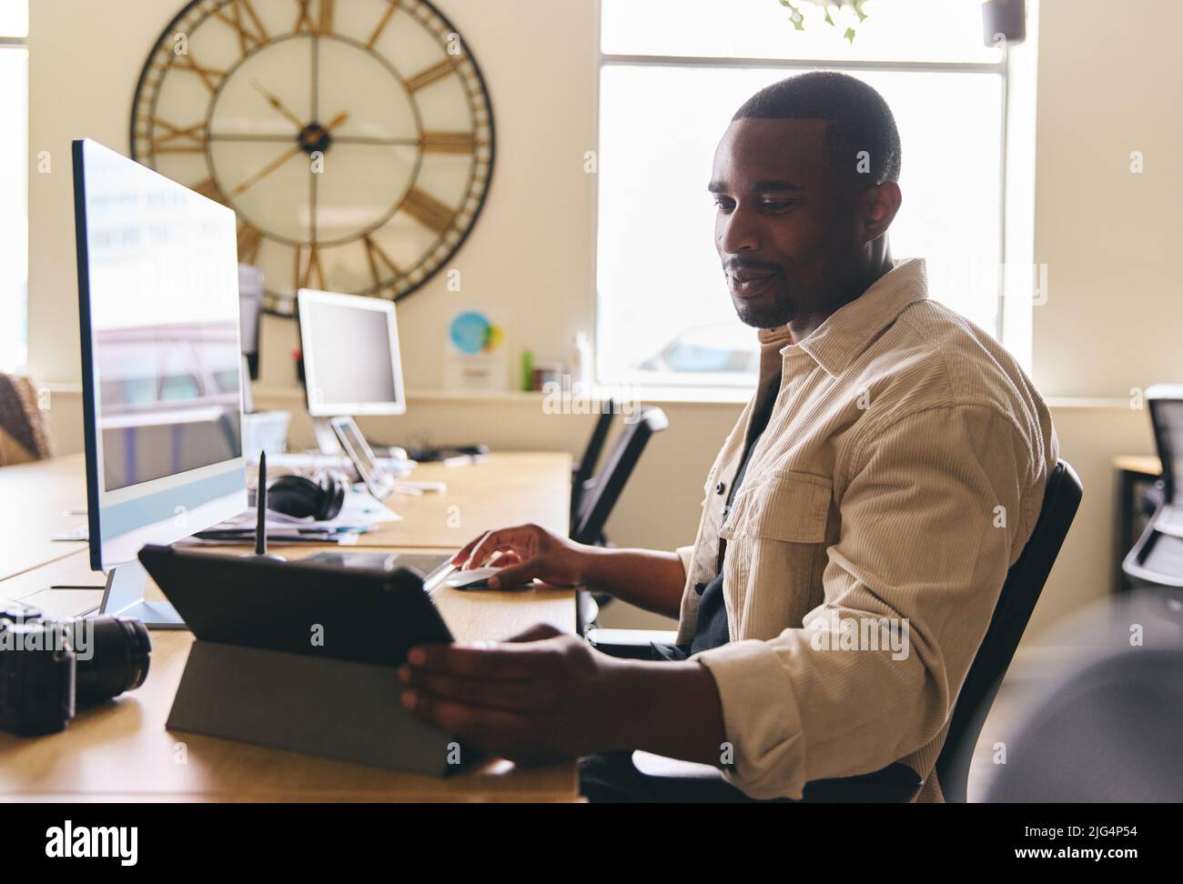 Young creative black man working on computer in modern office at desk ...