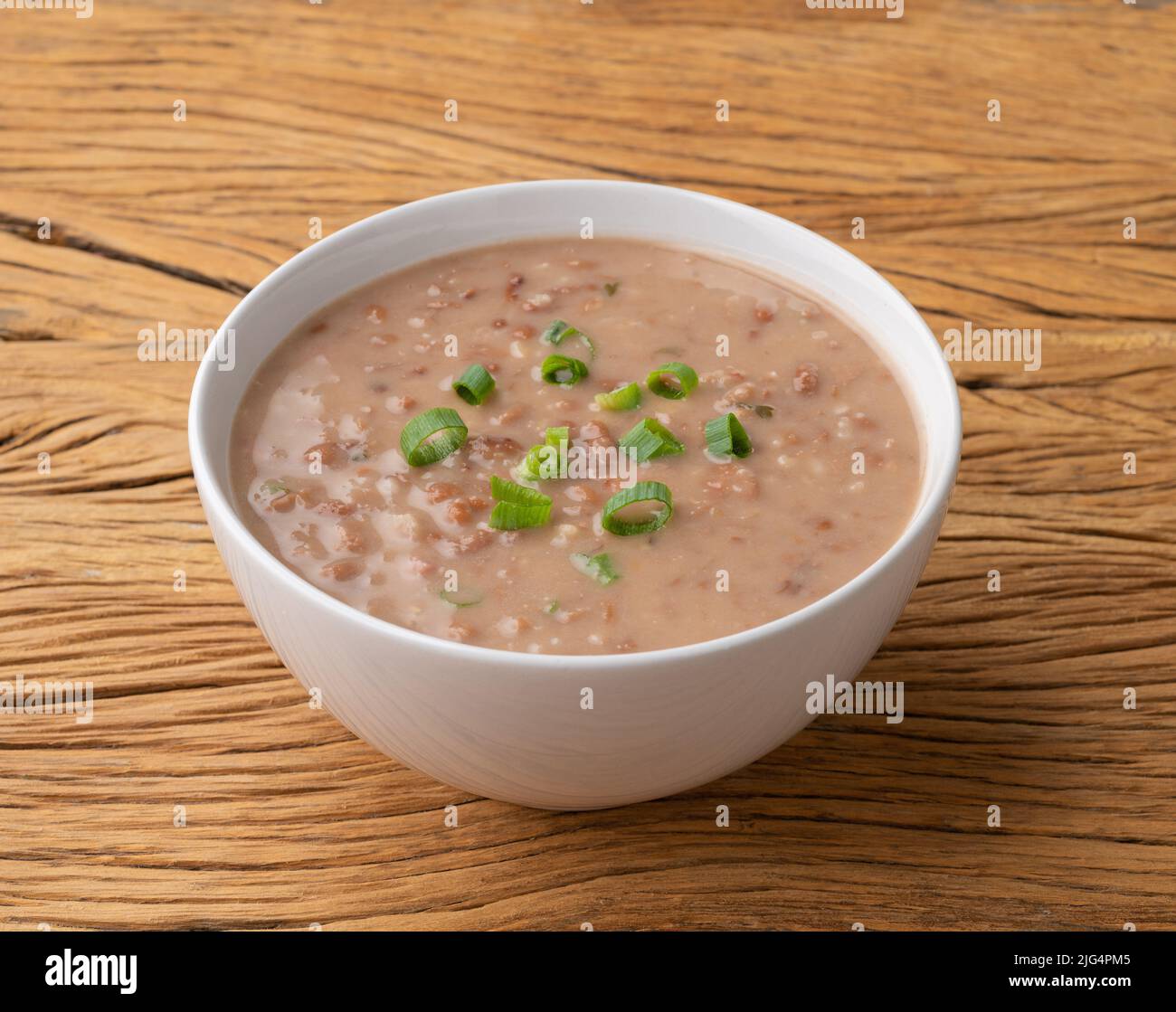 Brown bean soup in a bowl over wooden table Stock Photo - Alamy