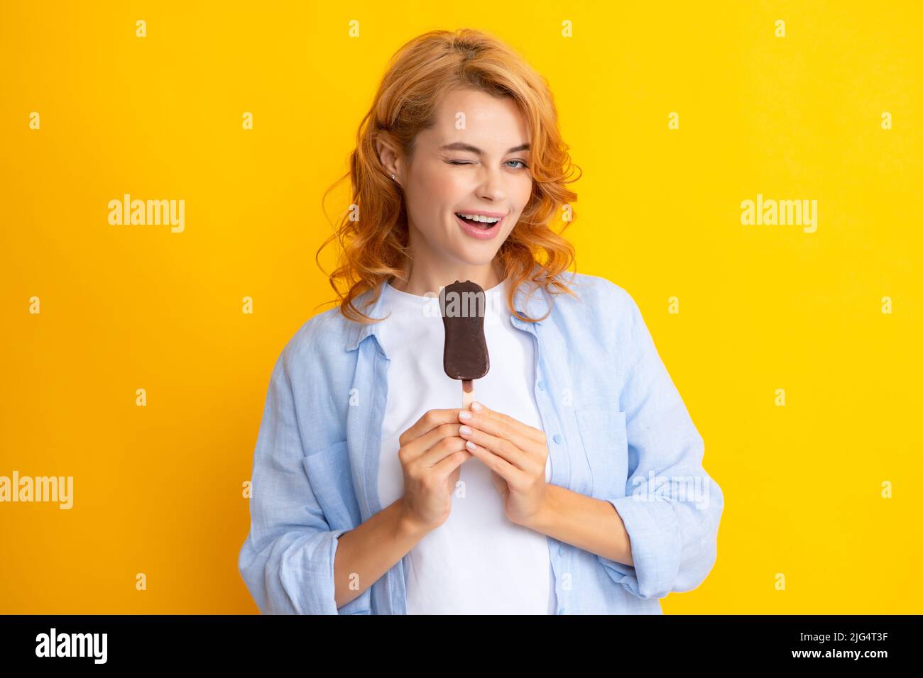 Summer concept. Winks woman holds tasty frozen ice cream, enjoys eating ...