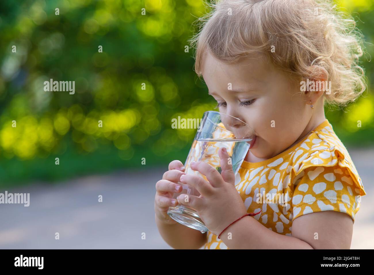 The child drinks water from a glass. Selective focus. Kid Stock Photo - Alamy