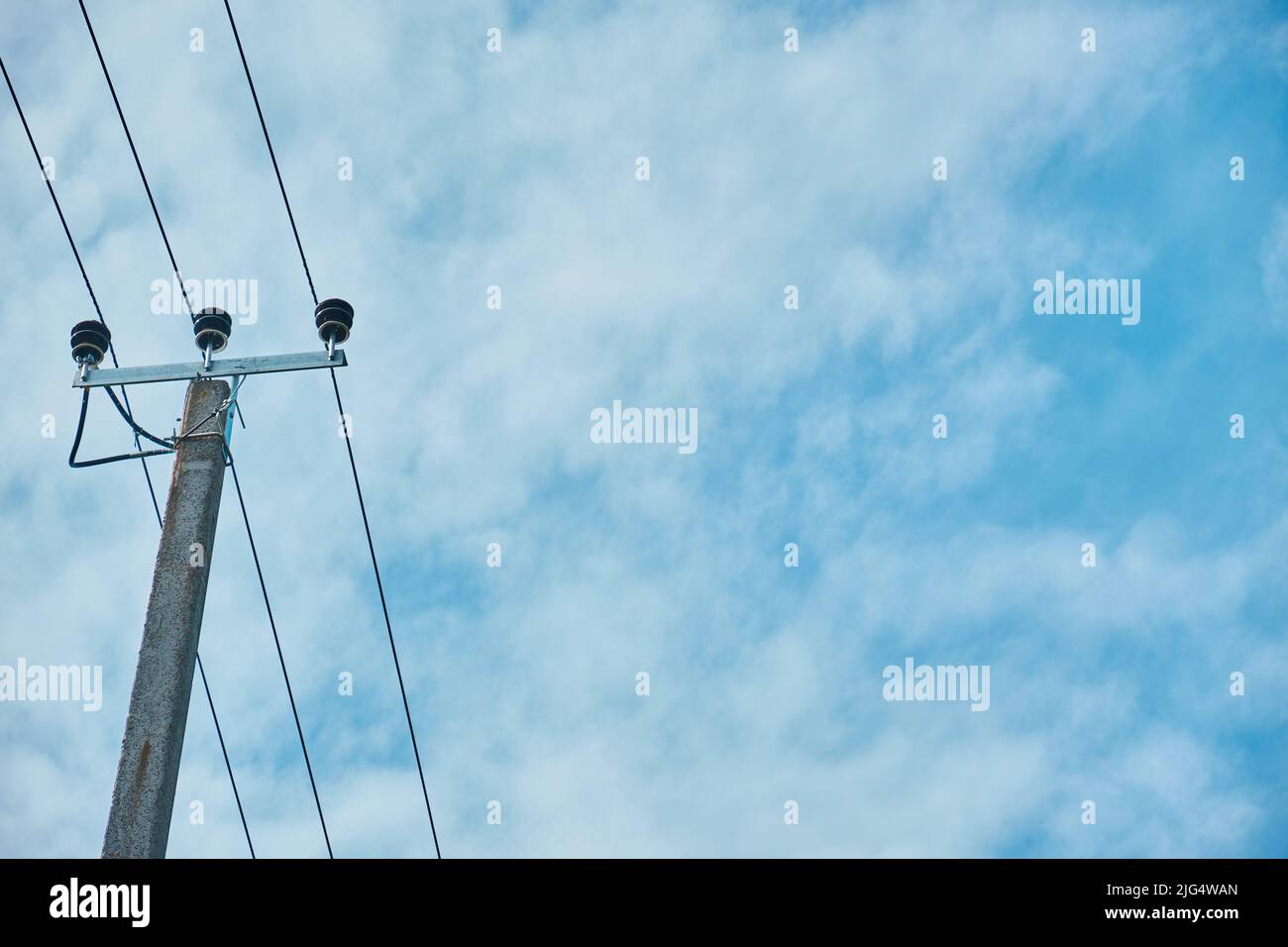 High voltage electric pylon and electrical wire at green rice field and ...