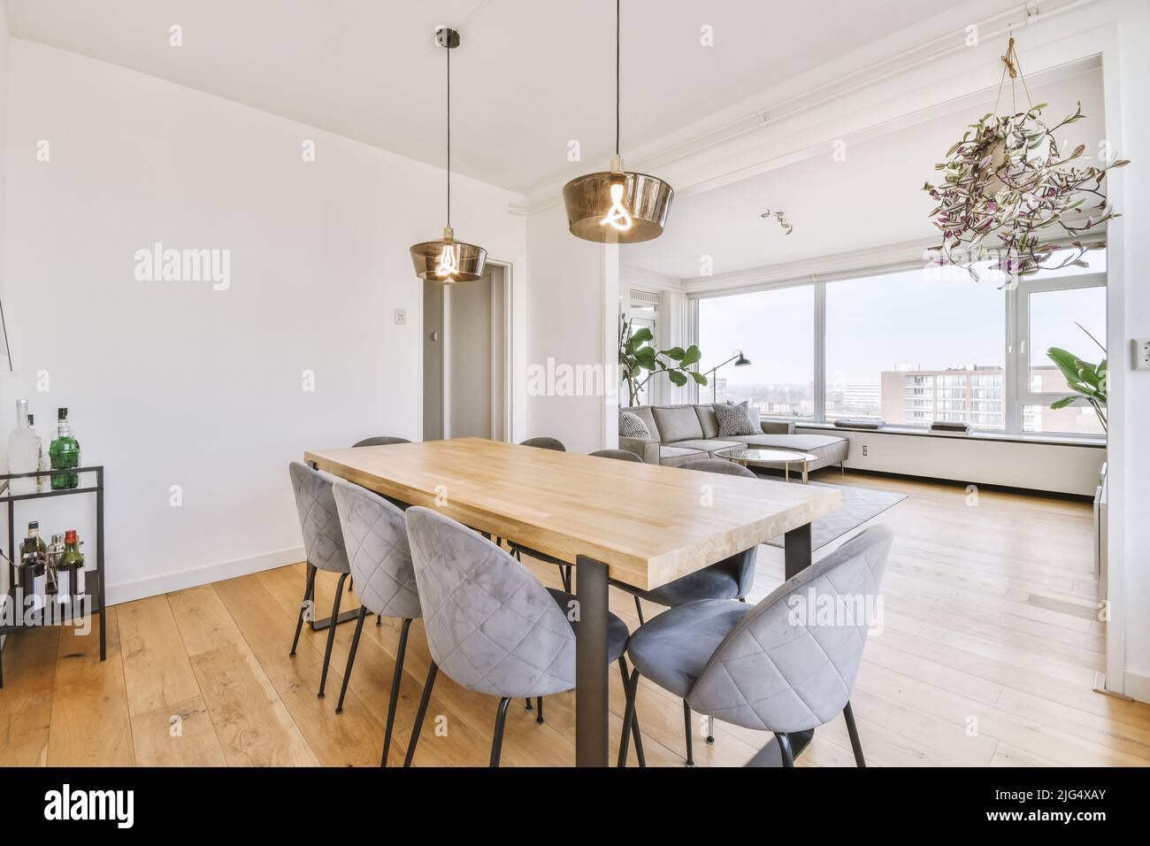 Interior of light room with stylish dining and lounge areas in modern ...