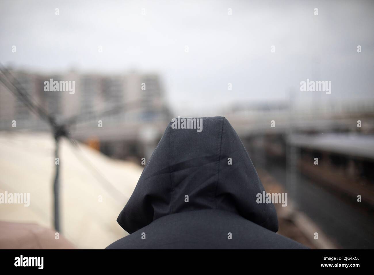 Black hood outside. Unknown person in city. Hidden face. Anonymity in ...