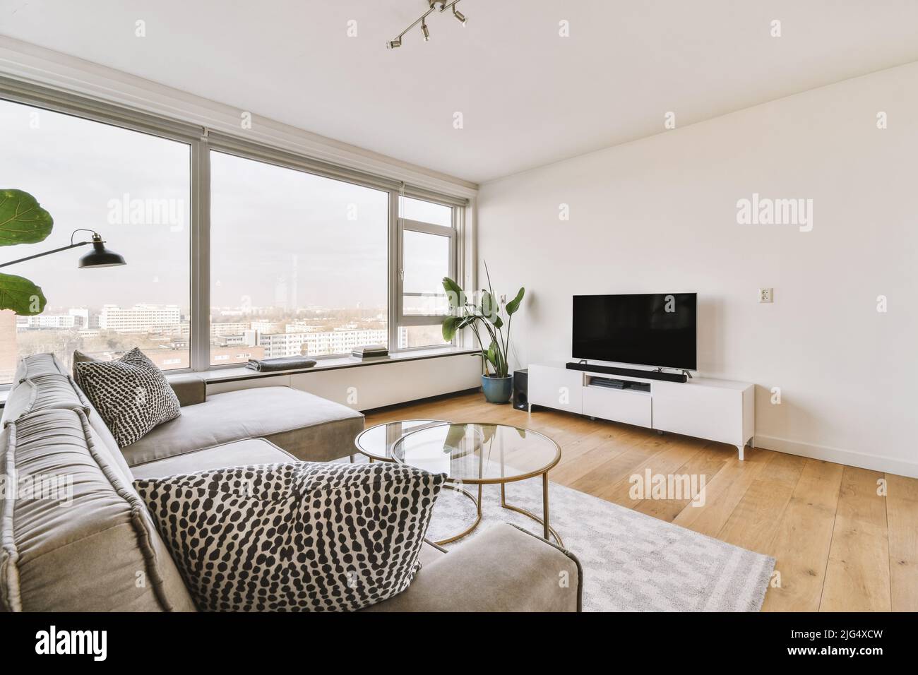 The interior of a modern living room with large panoramic windows, a ...