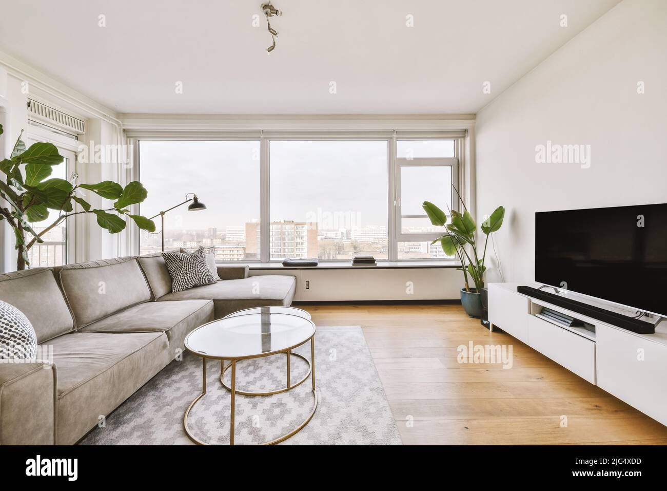 The interior of a modern living room with large panoramic windows, a ...