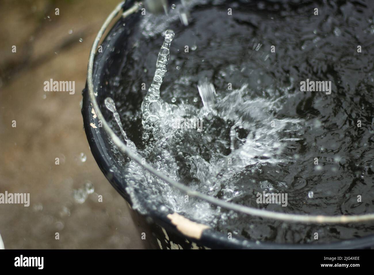 Drops of water. Water in bucket. Rain is falling. Splashes of water ...