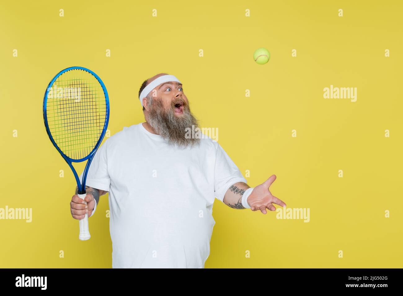 amazed overweight man with racquet playing with tennis ball isolated on ...