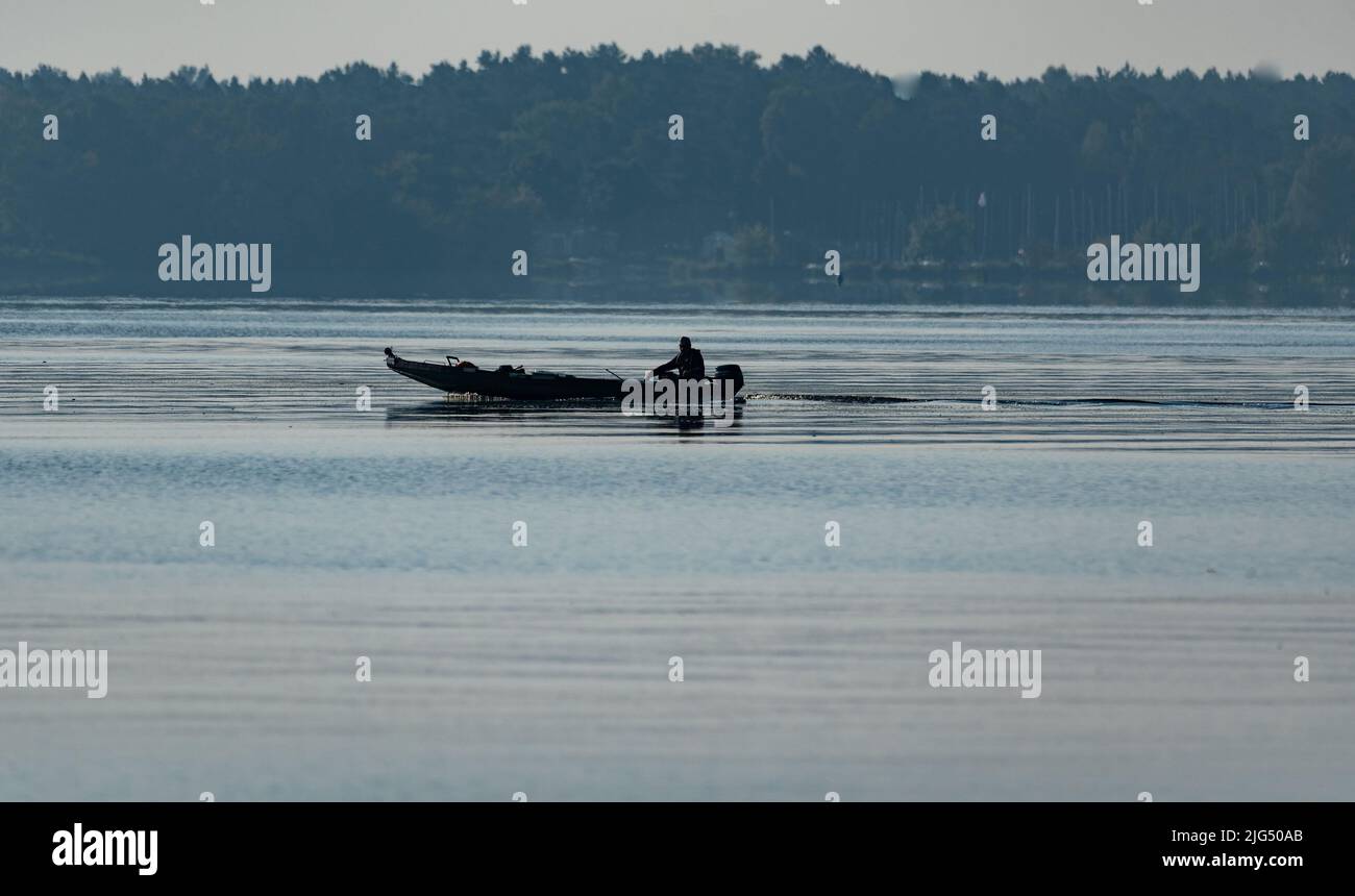 Zegrze, Poland - September 8, 2021: Angler in a boat with an internal ...