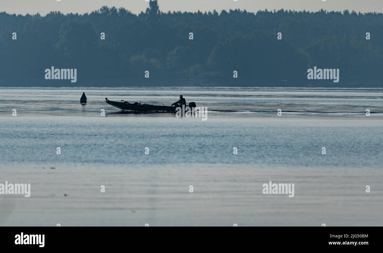 Zegrze, Poland - September 8, 2021: Angler in a boat with an internal ...