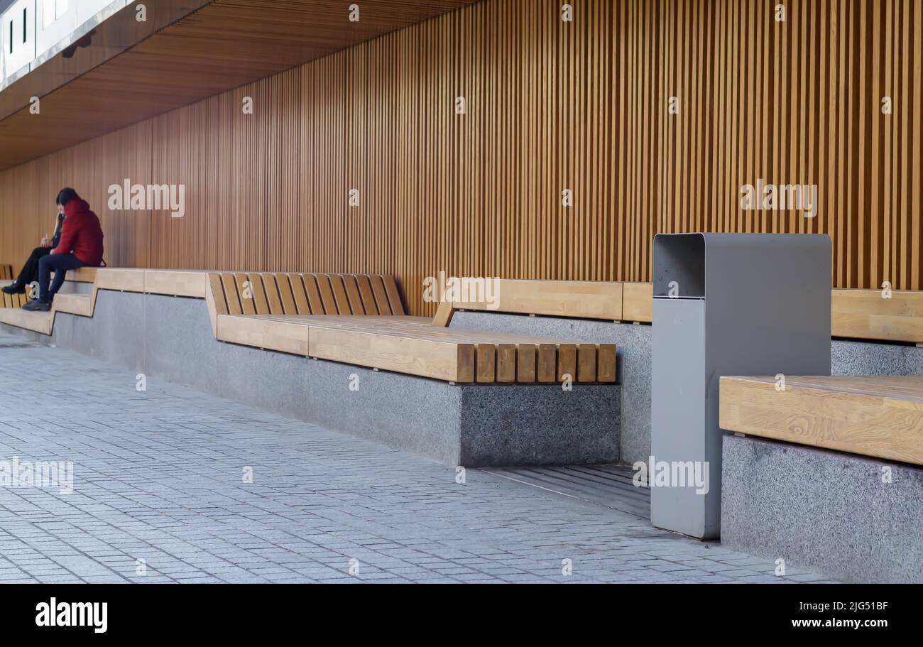 Modern wooden benches on a sunny day, public places in the city park. City improvement, urban ...