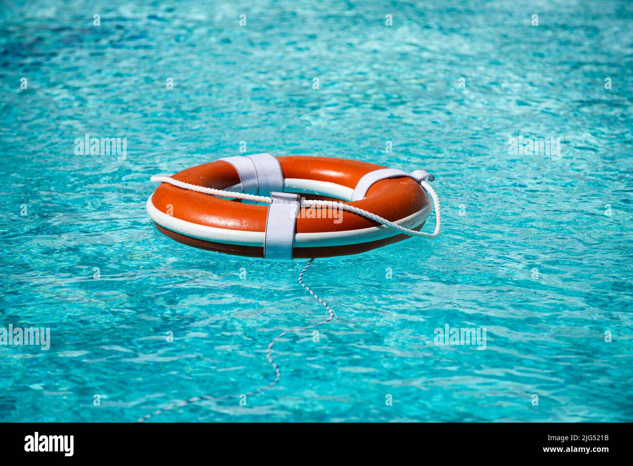 Life buoy in blue swimming pool. Lifebuoy pool ring float on blue water ...