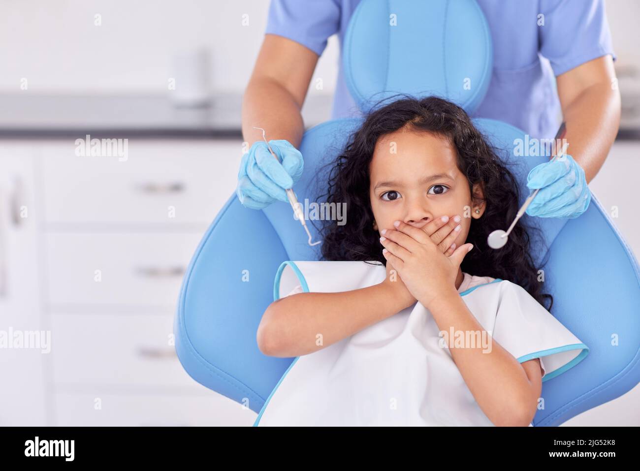 Ready for your tooth repair. Shot of a young girl looking scared while ...