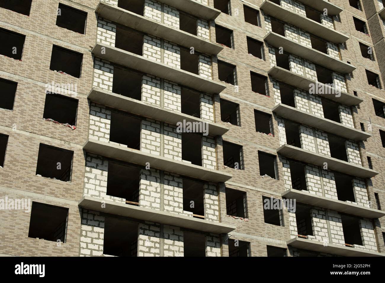 Empty windows in building. Unfinished house in city. Construction on ...