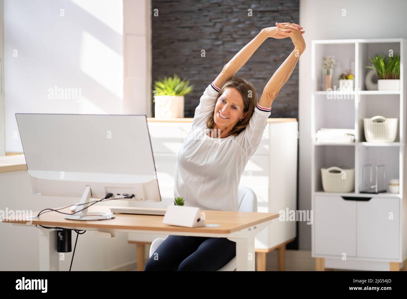 Woman Stretches At Office Desk. Stretch Exercise On Chair Stock Photo ...
