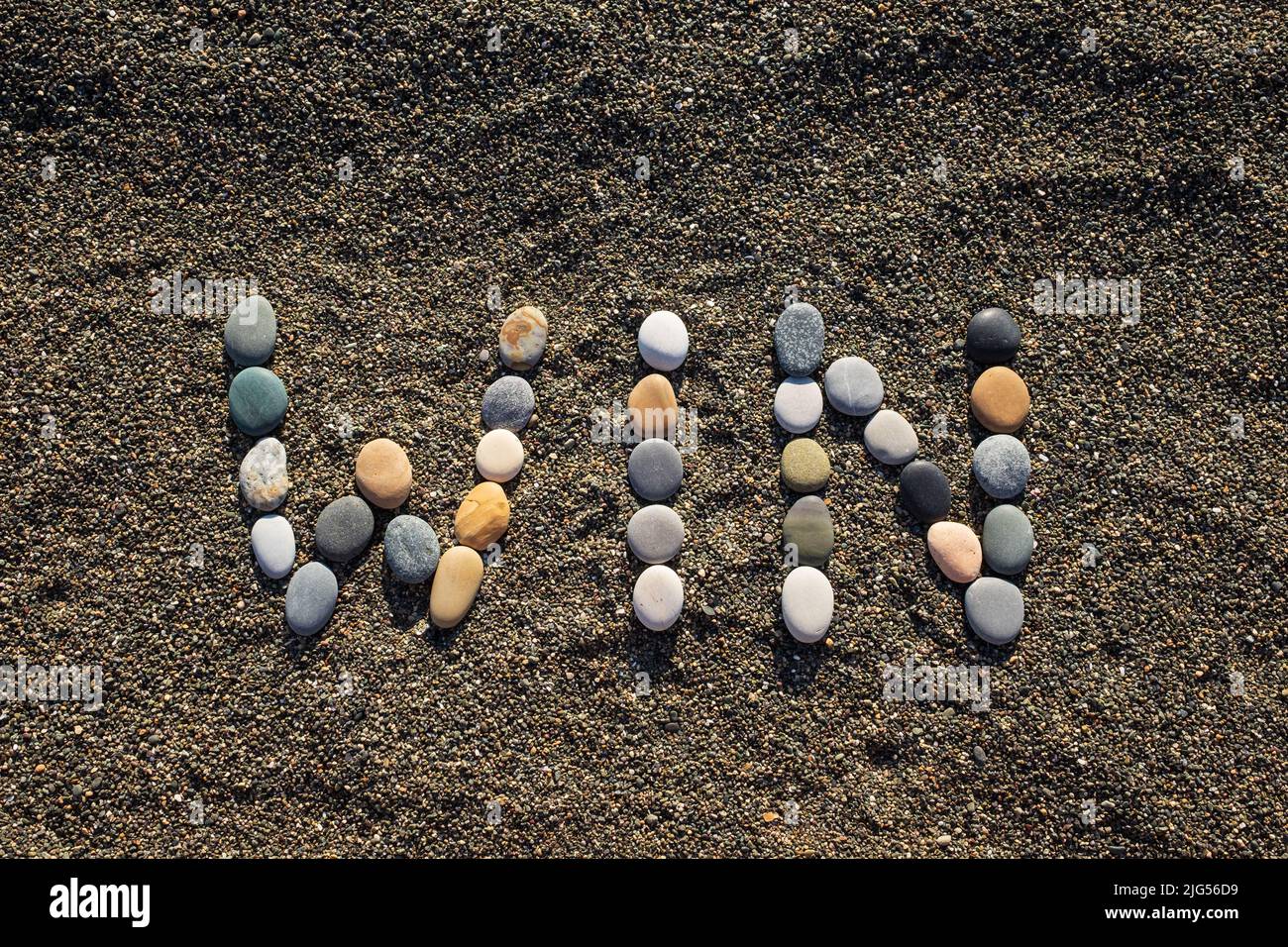 Word win made from stones on sandy beach. Success concept Stock Photo ...