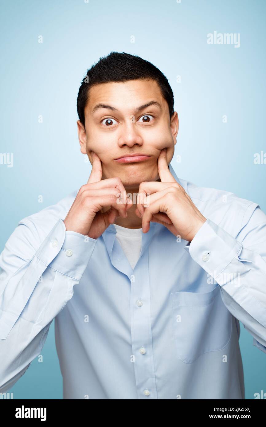 What a cute face. Shot of a young man making facial expressions against ...