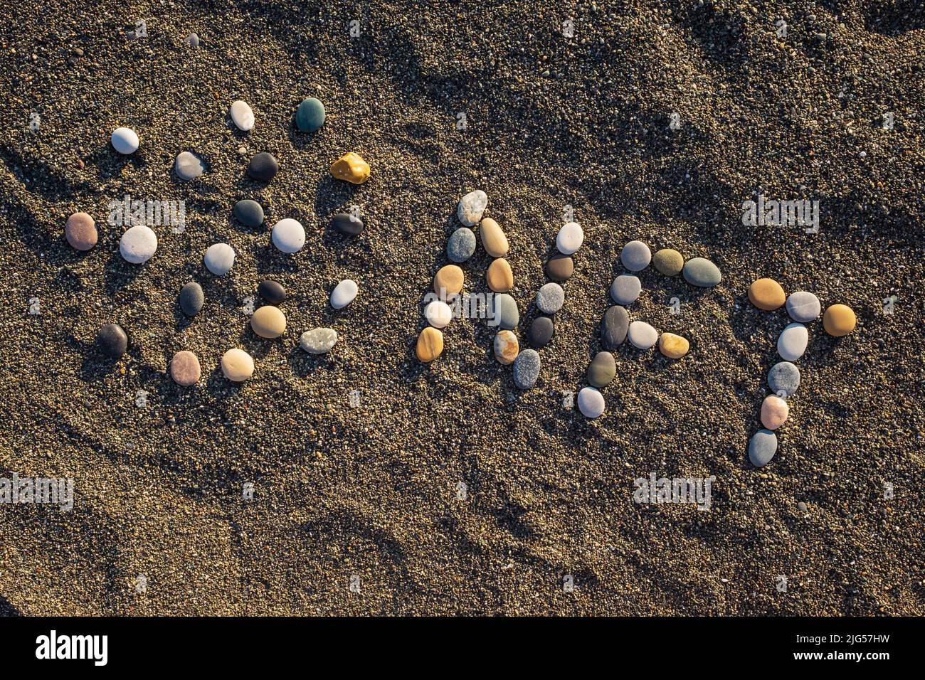 Concept of non-fungible NFT tokens. NFT text made from stones on beach ...